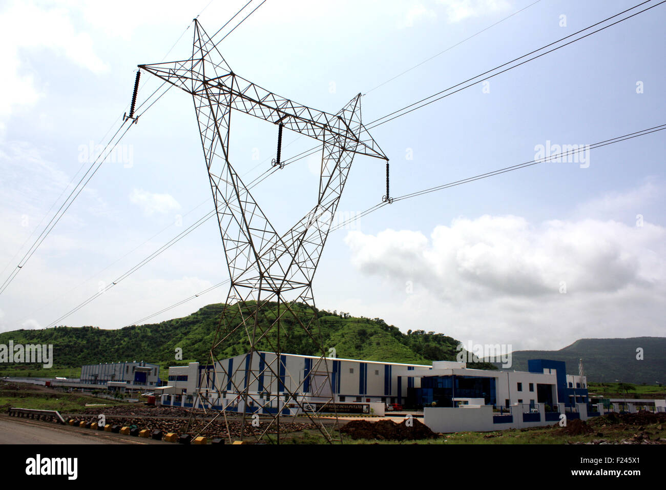 A tower of power cable lines leading to huge factories, in India Stock ...