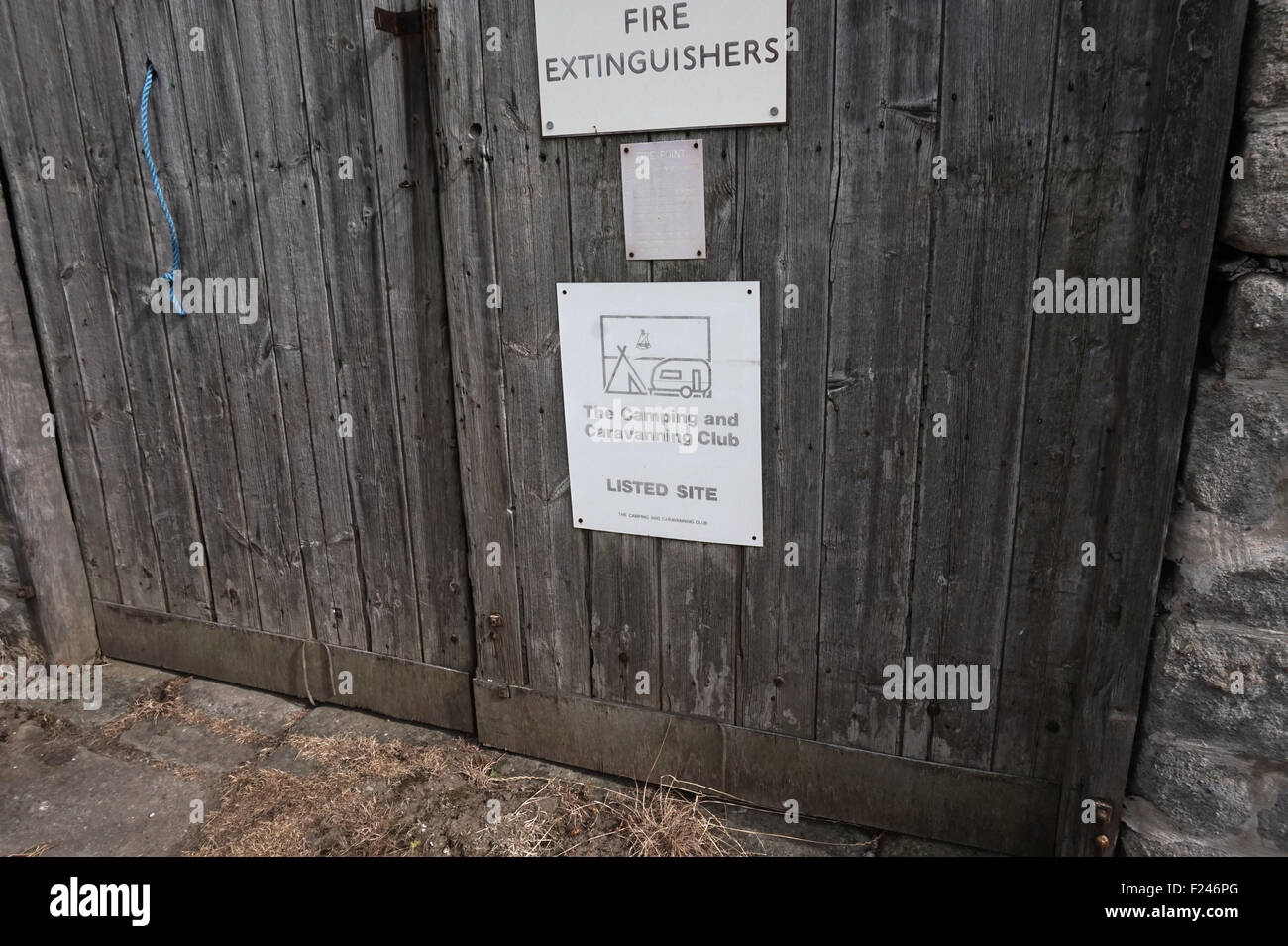 Signs on a barn door for fire extinguishers and a The Camping and ...