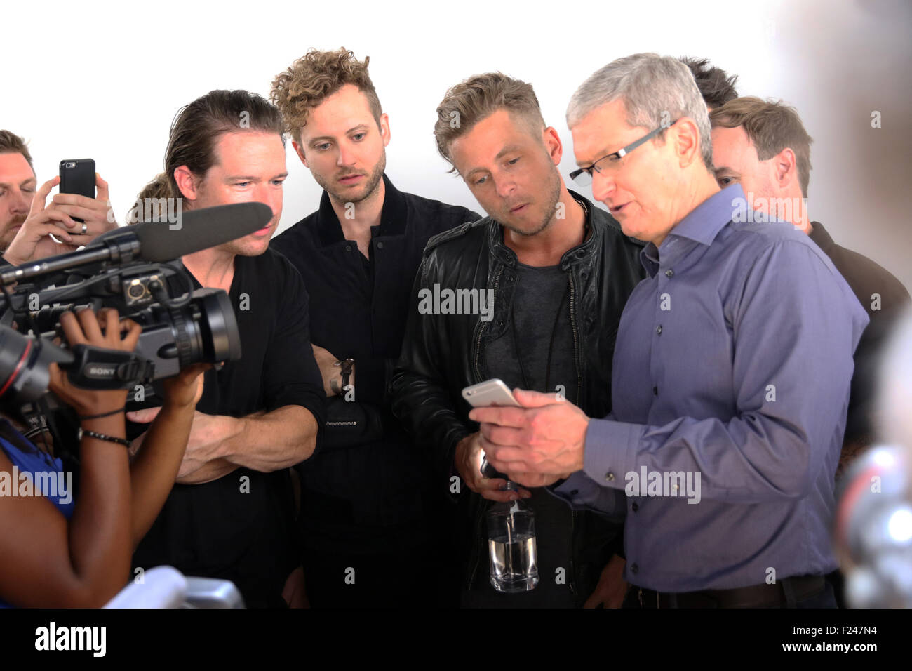 Apple boss Tim Cook (r) shows members of the US rock band OneRepublic ...