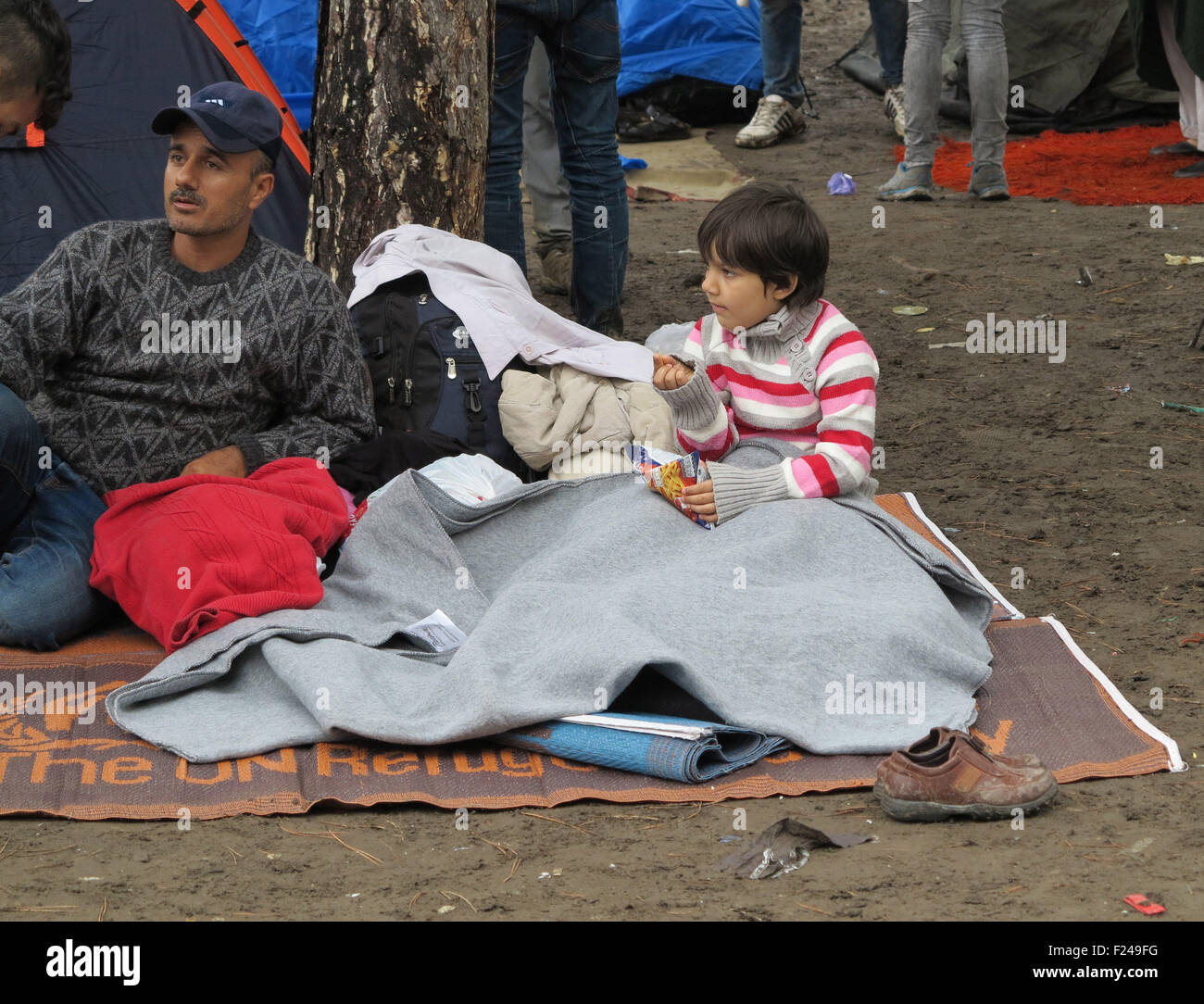 Refugees sit on blankets provided by UNHCR at the bus station in ...