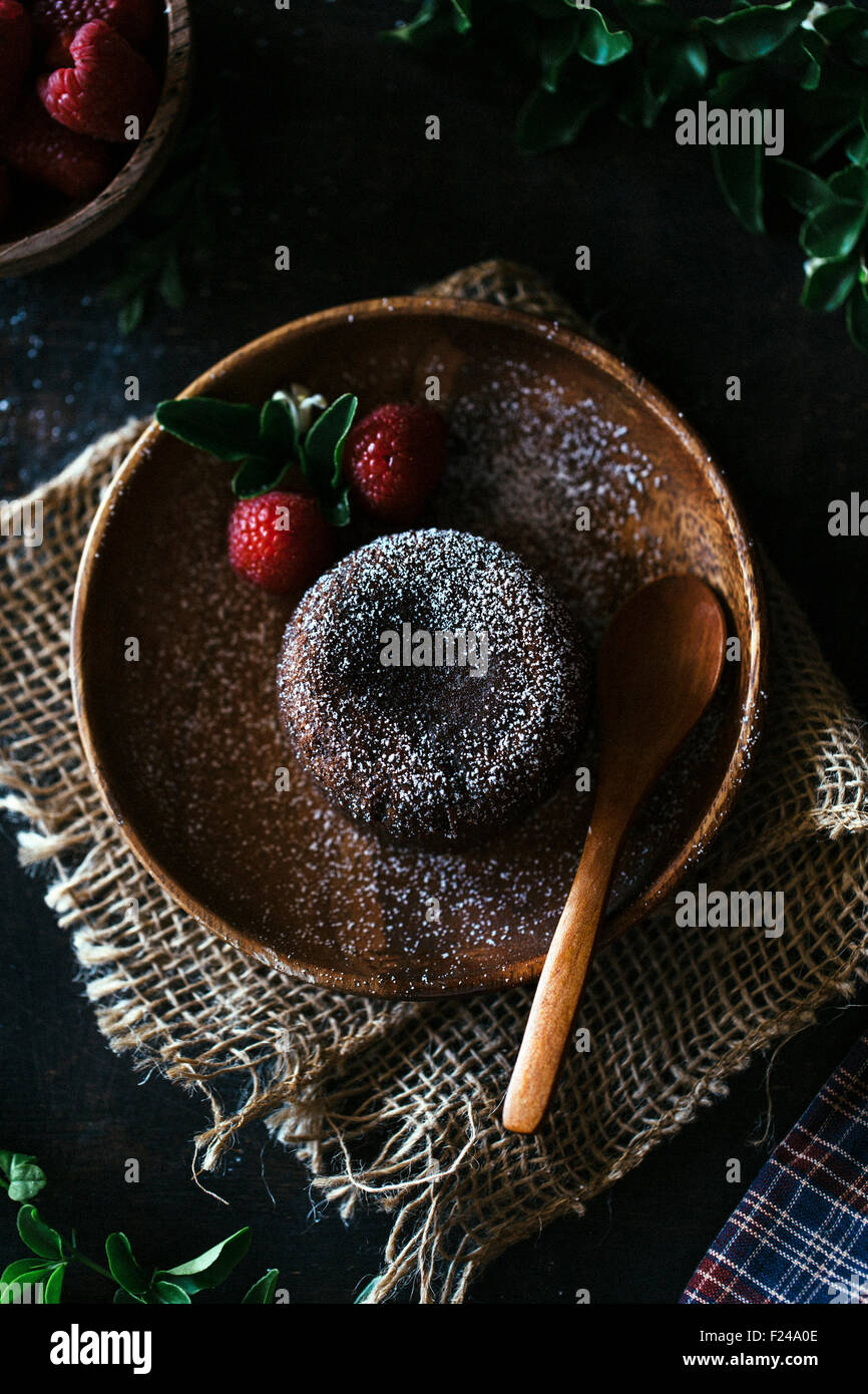 An individual portion of chocolate fondant is served with raspberries ...