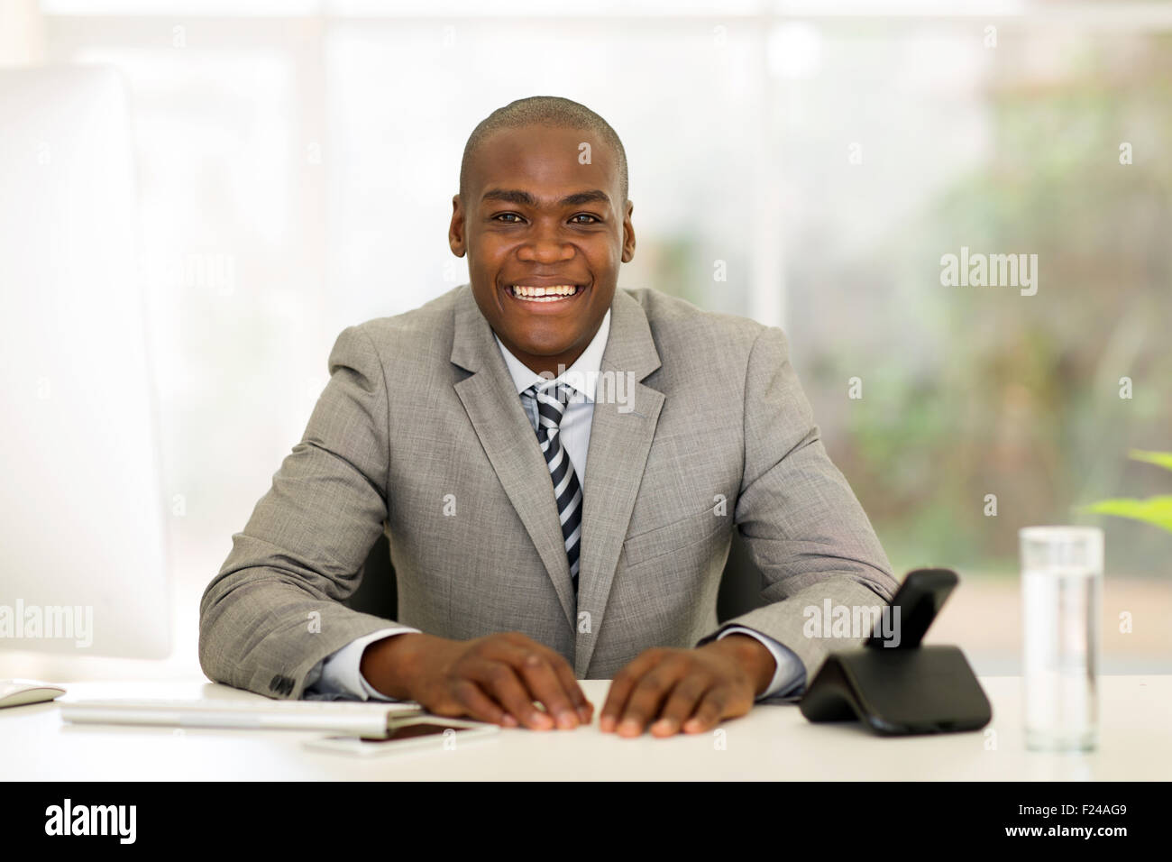 happy African businessman sitting in modern office Stock Photo - Alamy
