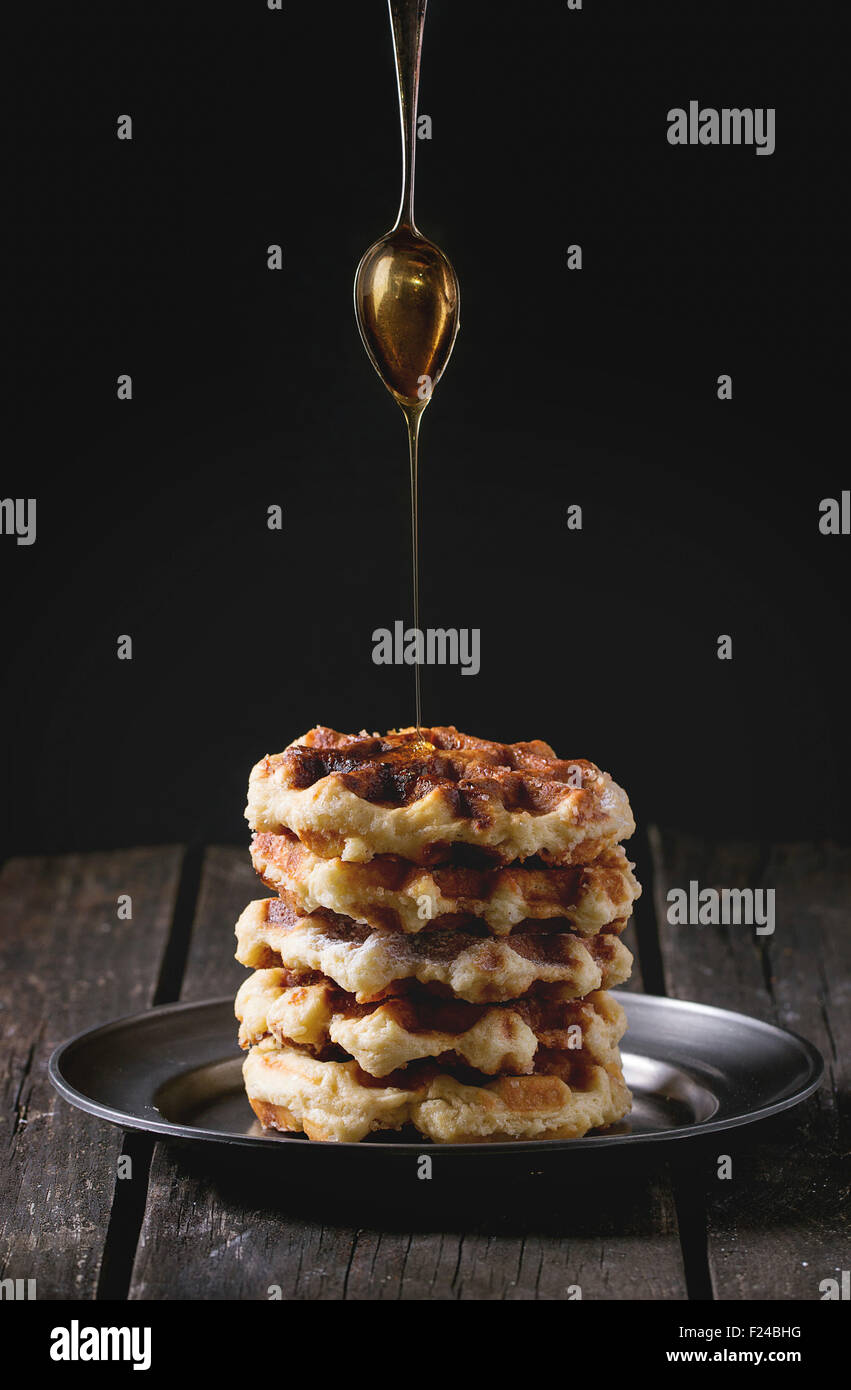 Metal plate with homemade belgian waffles with pouring syrup from tea ...