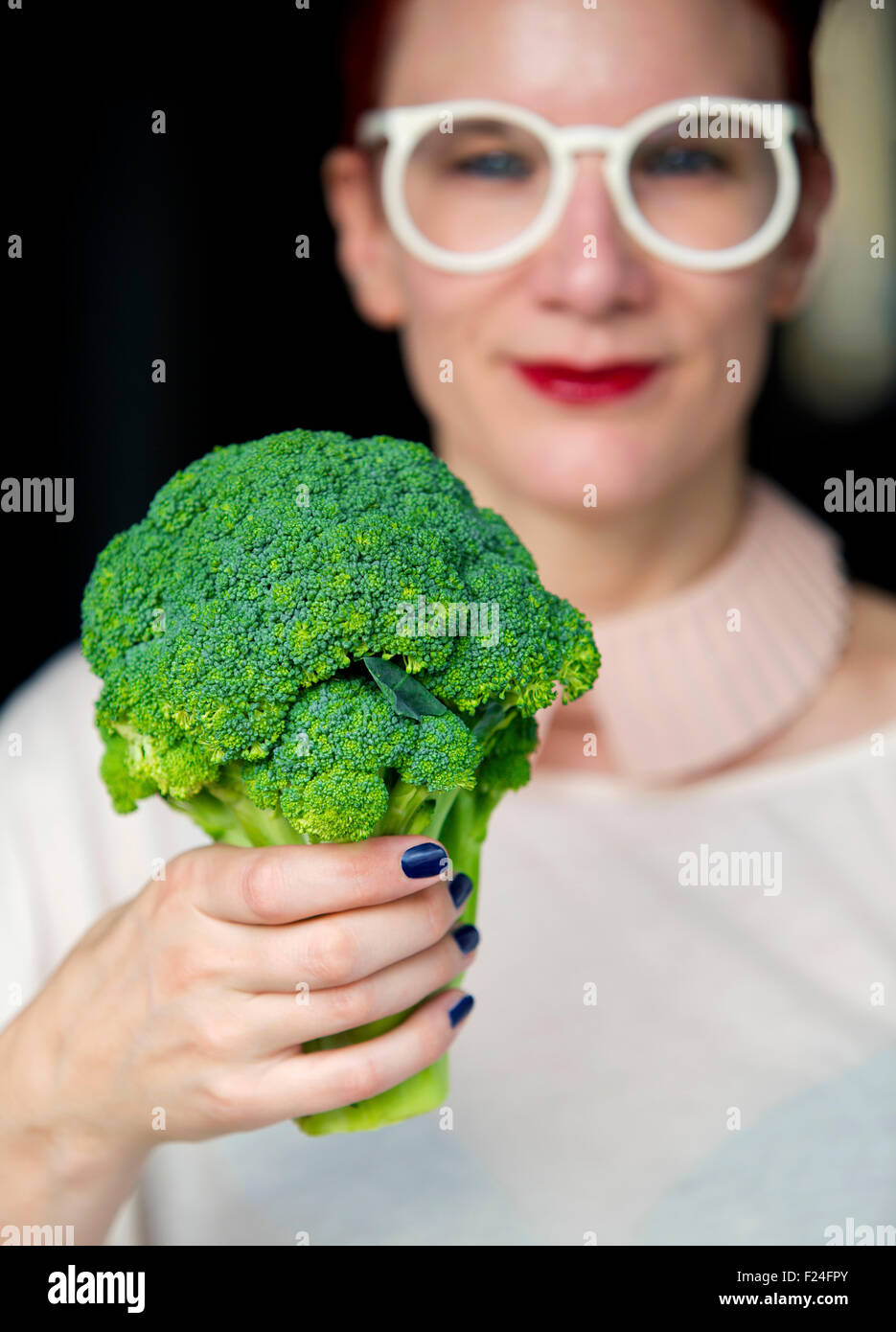 closeup of woman holding broccoli in her hand Stock Photo - Alamy