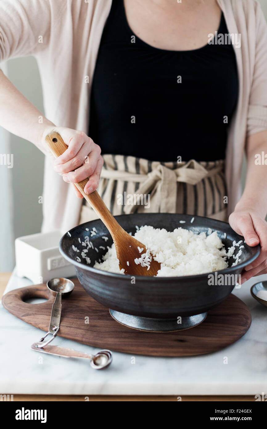 The making of sushi. Woman mixing rice in a bowl Stock Photo - Alamy