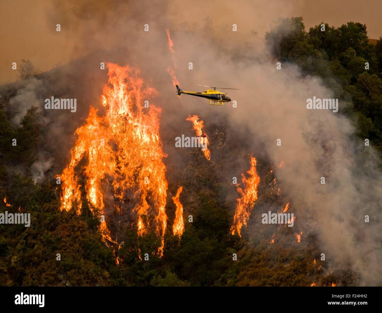 A helicopter drops fire retardant on the East Basin Complex blaze in ...