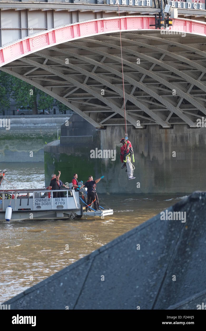 Firemen rescue a man who had climbed underneath Lambeth Bridge. The ...