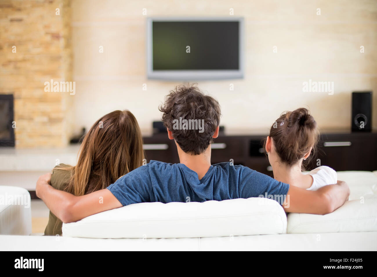 Young people watching tv Stock Photo - Alamy