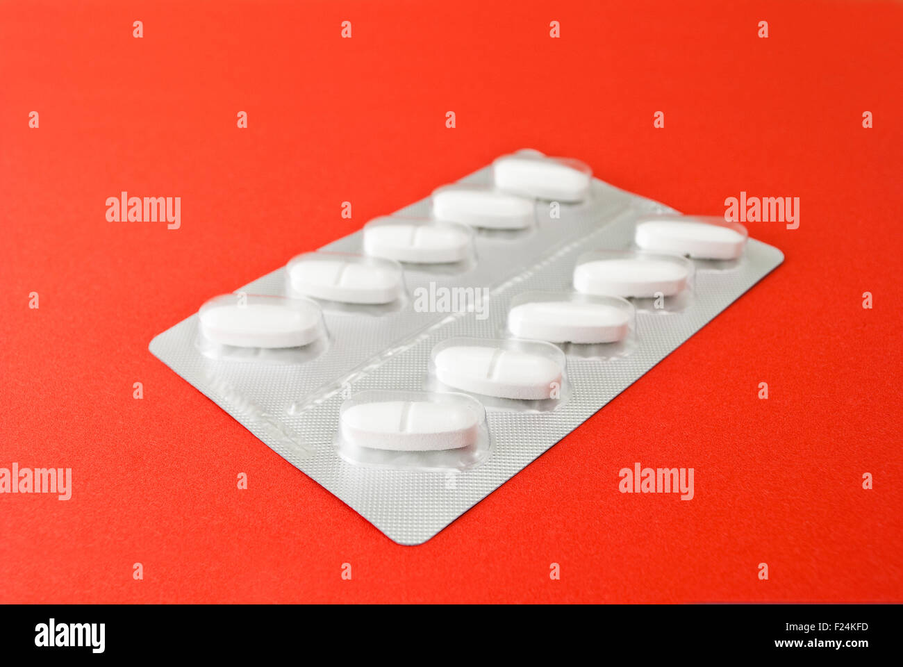 Silver packing of tablets on the red background Stock Photo - Alamy