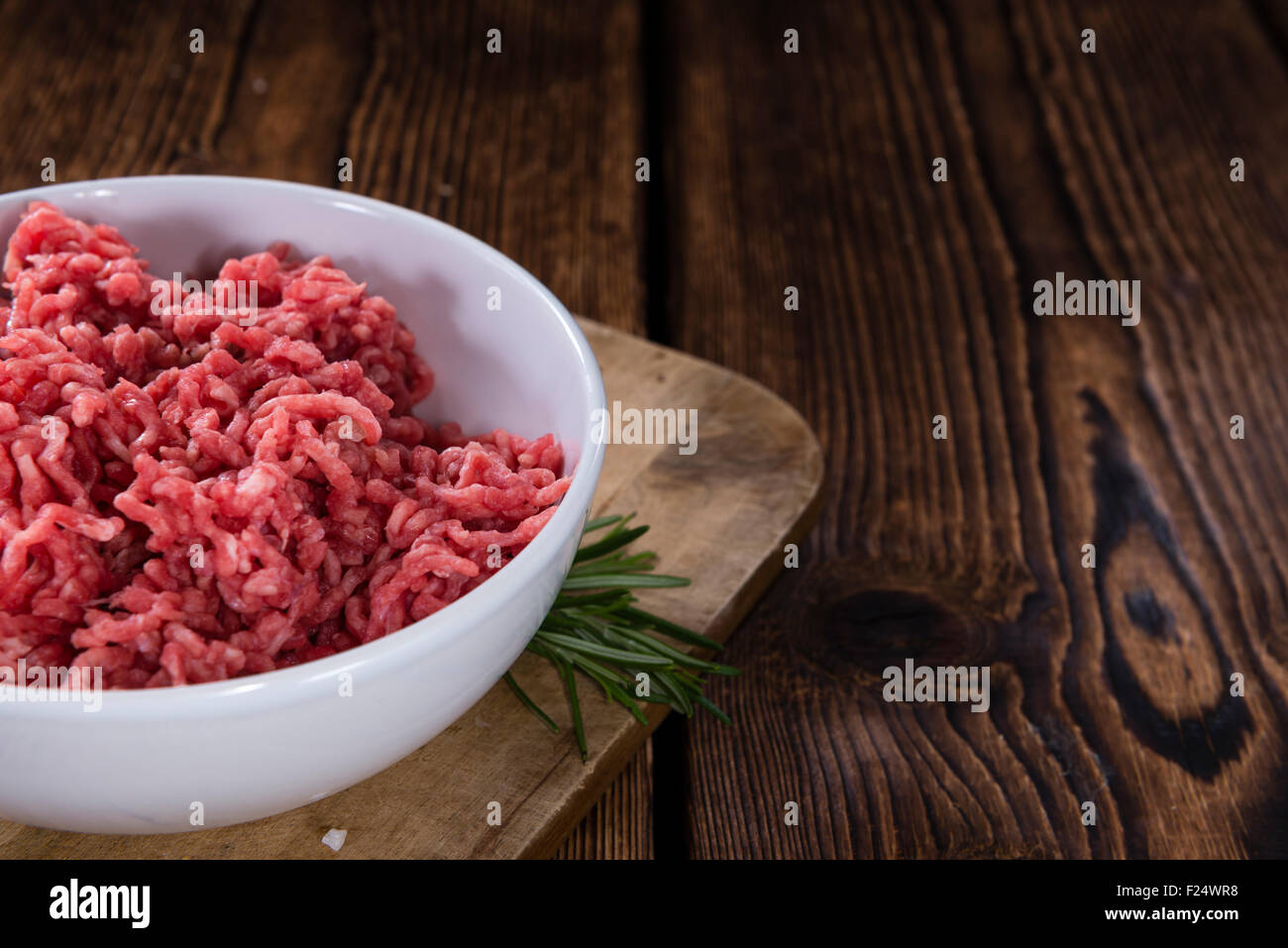 Minced Meat (Beef) as detailed close-up shot on dark wooden background ...