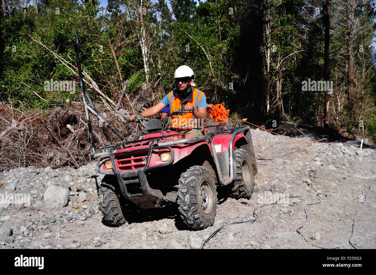 Men use an all terrain vehicle for setting out cables in a seismic ...