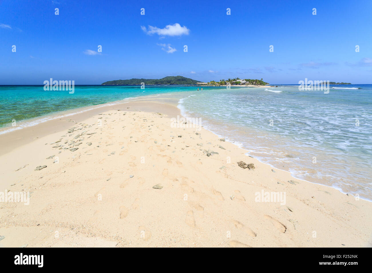 Small spit of deserted beach disappearing into ocean between tropical ...