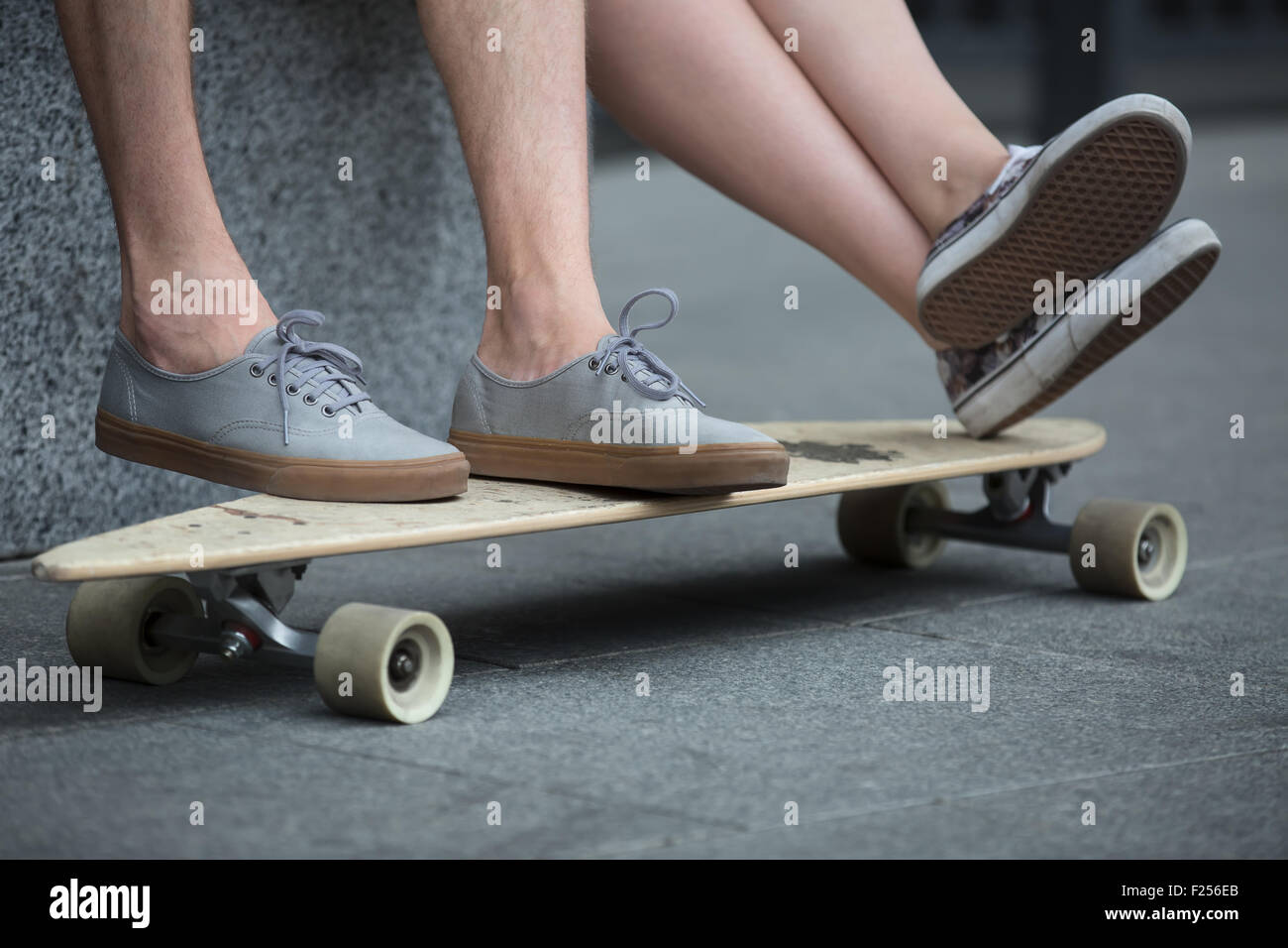 Feet couple of teenagers on the longboard closeup Stock Photo - Alamy