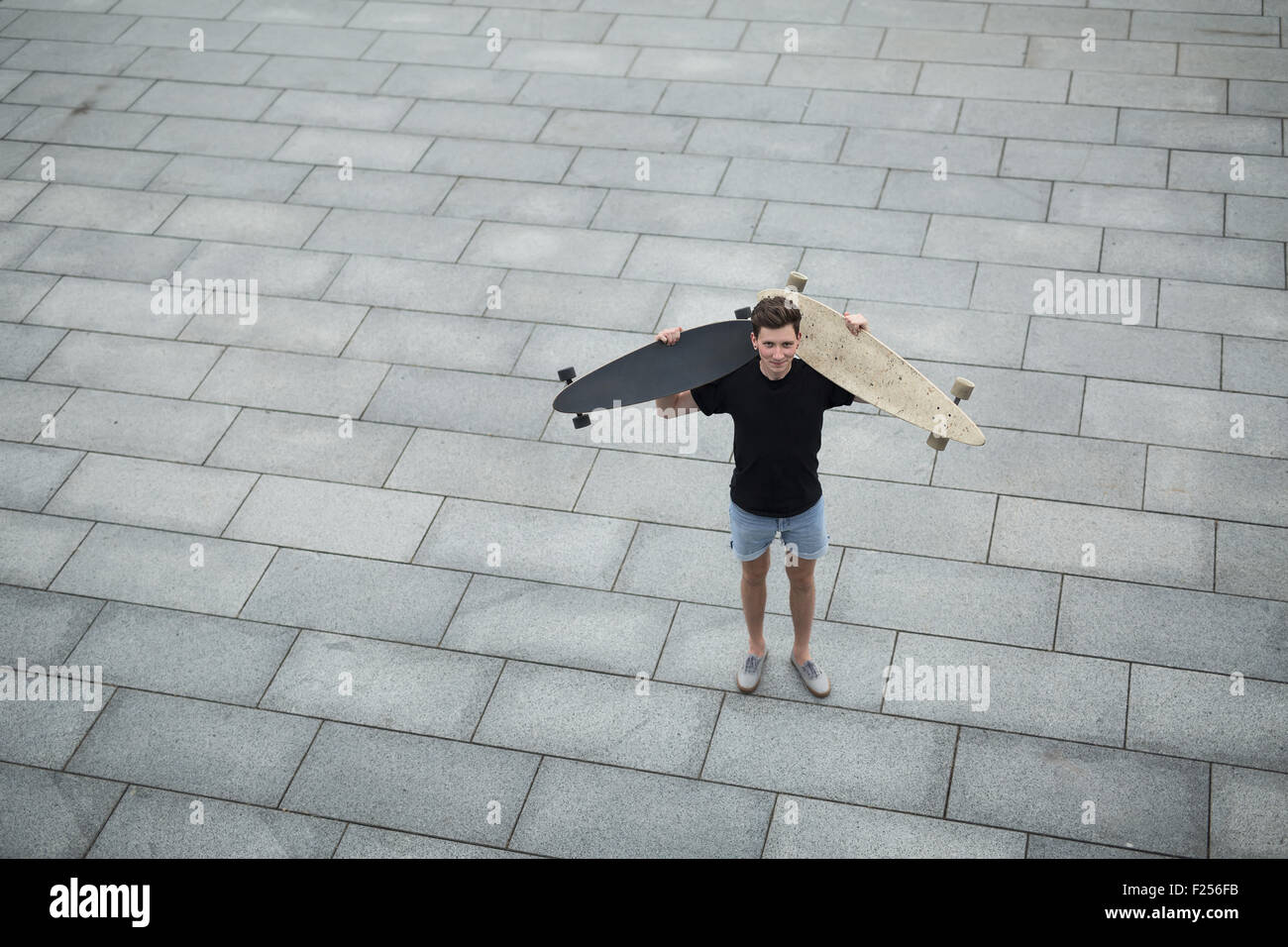 Young boy standing with two different longboard Stock Photo - Alamy