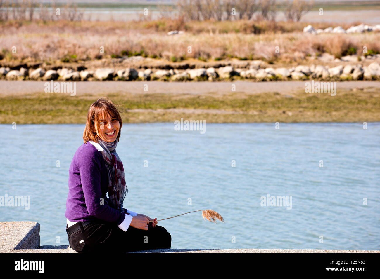 Woman sitting looking the river Stock Photo - Alamy