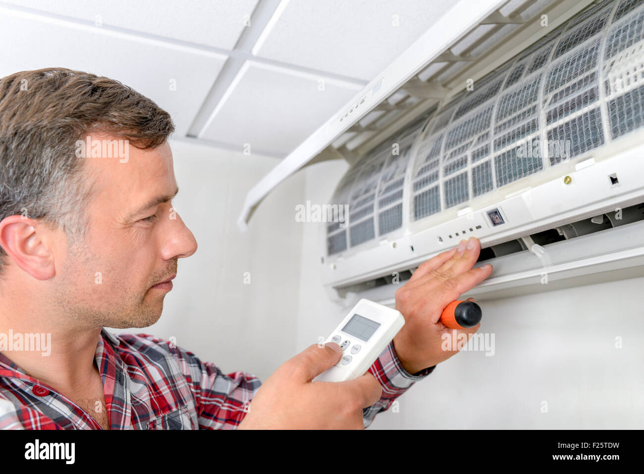 Man checking air conditioning unit Stock Photo - Alamy