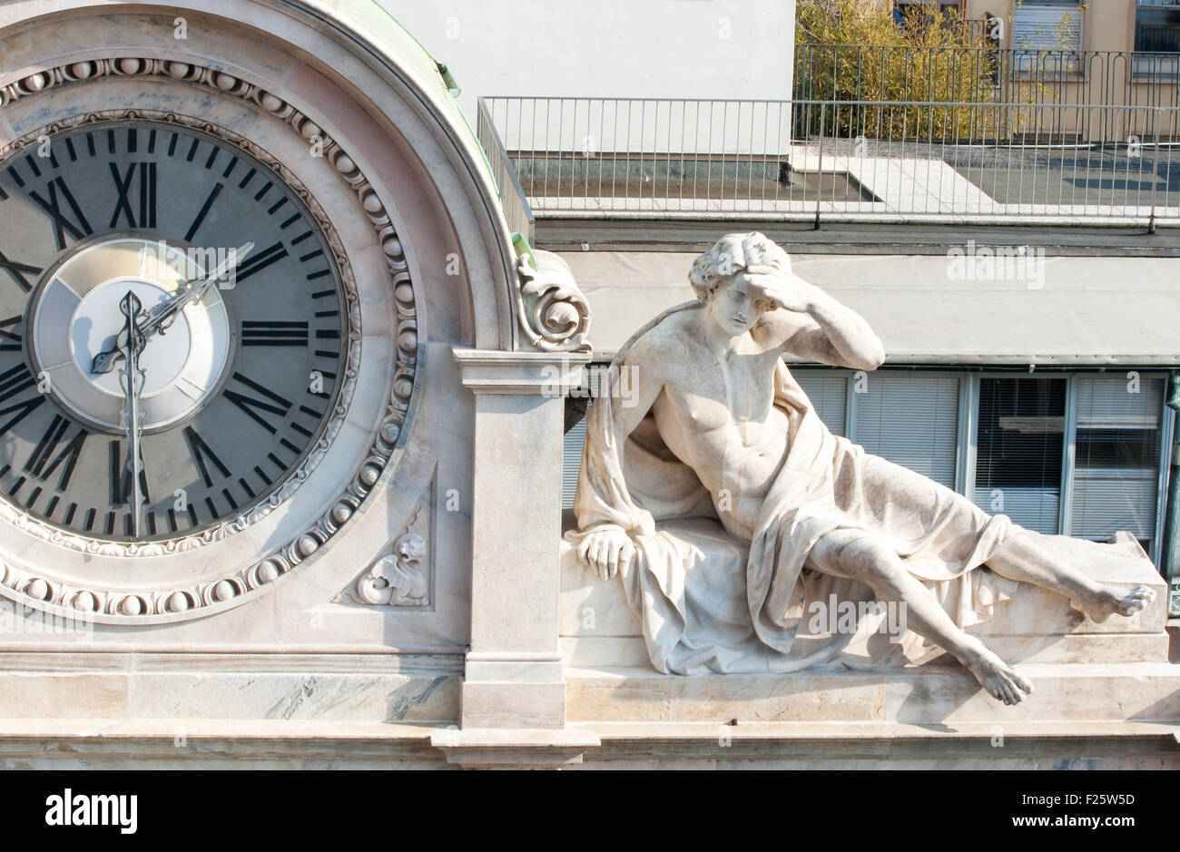 Clock and man statue, Milan Stock Photo - Alamy