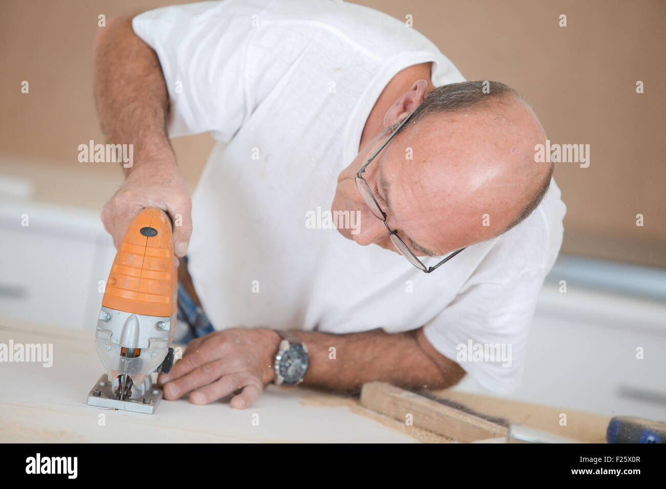 Man using jigsaw Stock Photo - Alamy