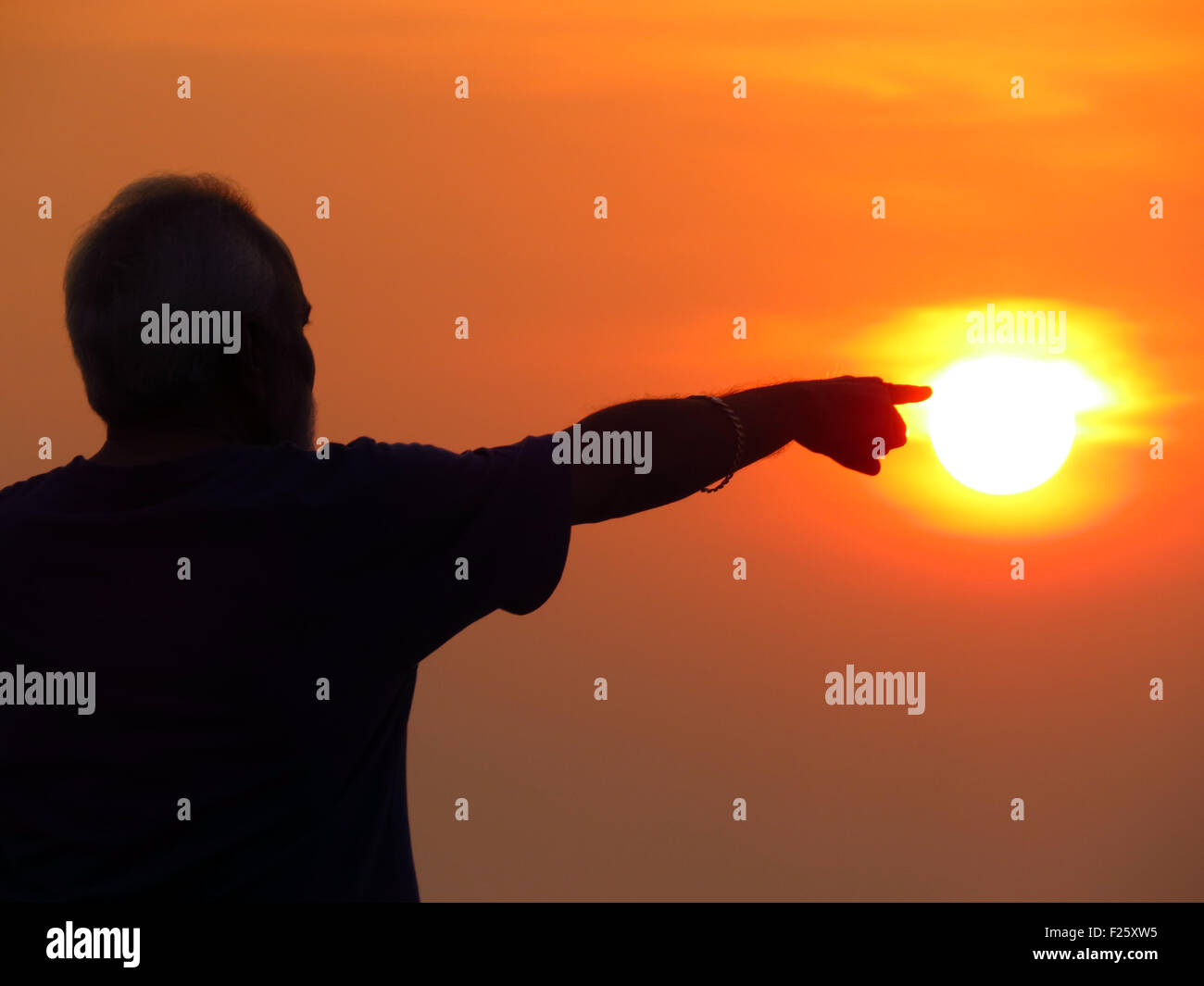 A metaphorical image showing a wide old Indian man pointing at the Sun ...