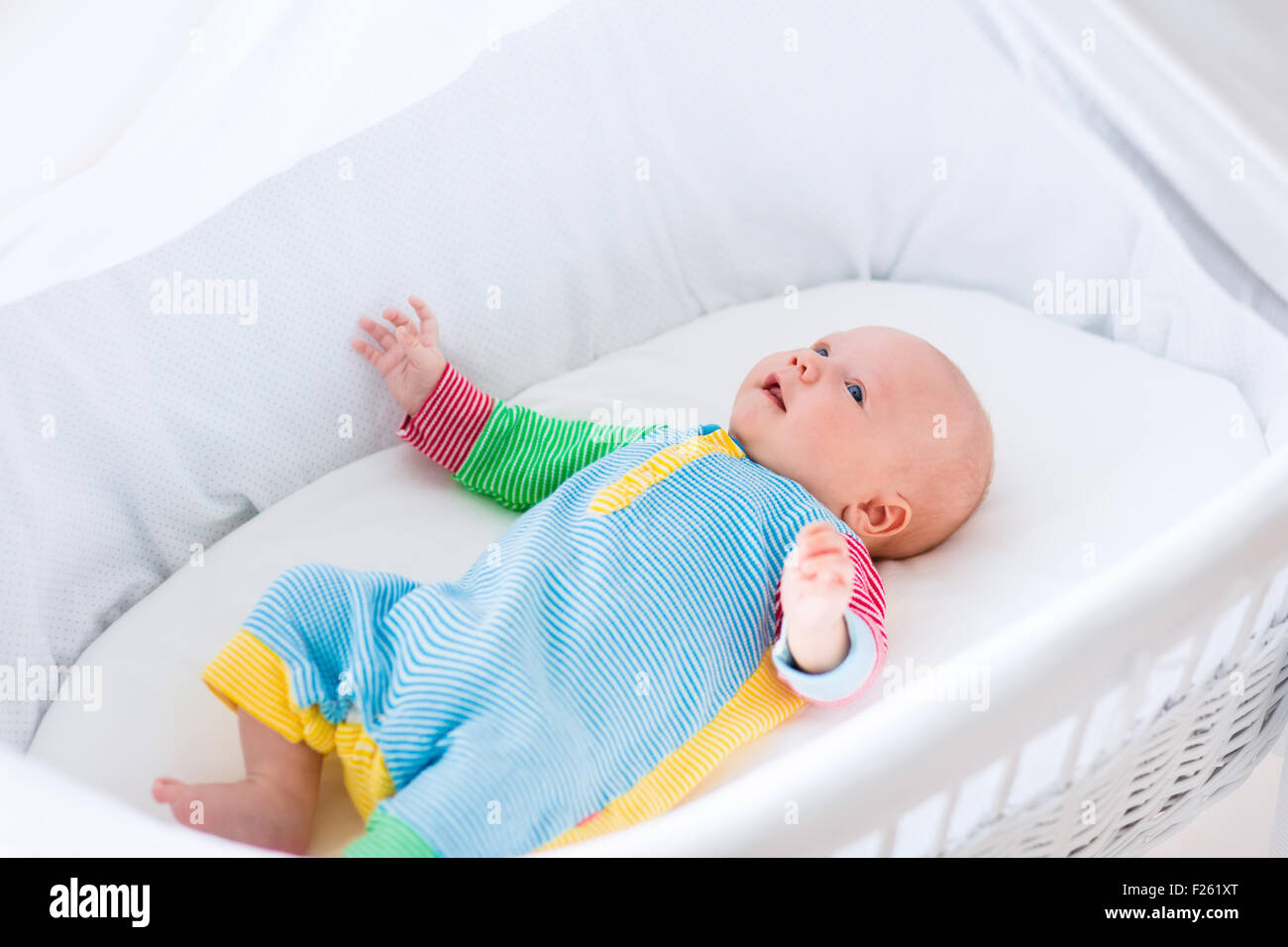 Newborn baby boy playing in bed on sunny morning. New born child ...