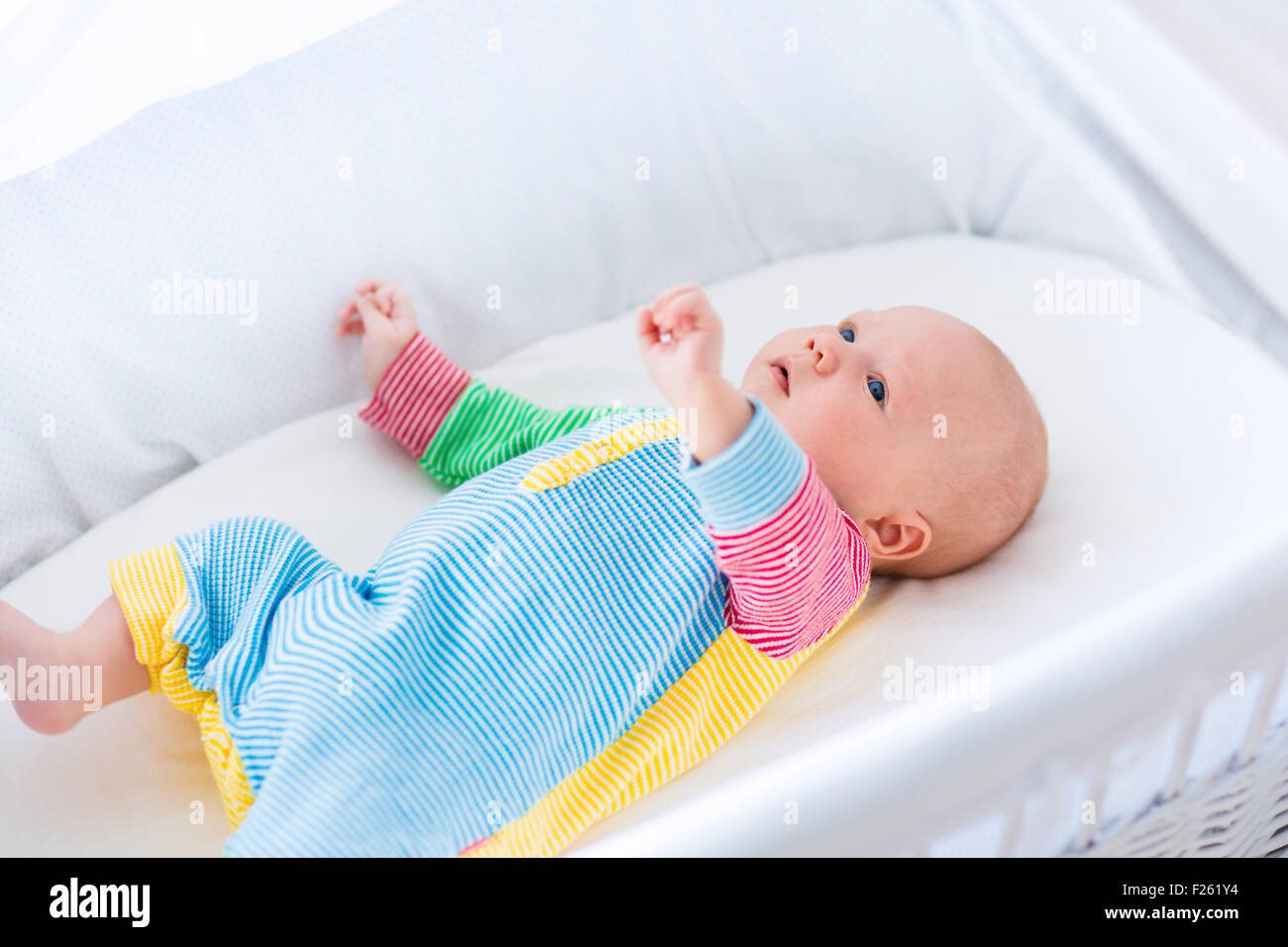 Newborn baby boy playing in bed on sunny morning. New born child ...