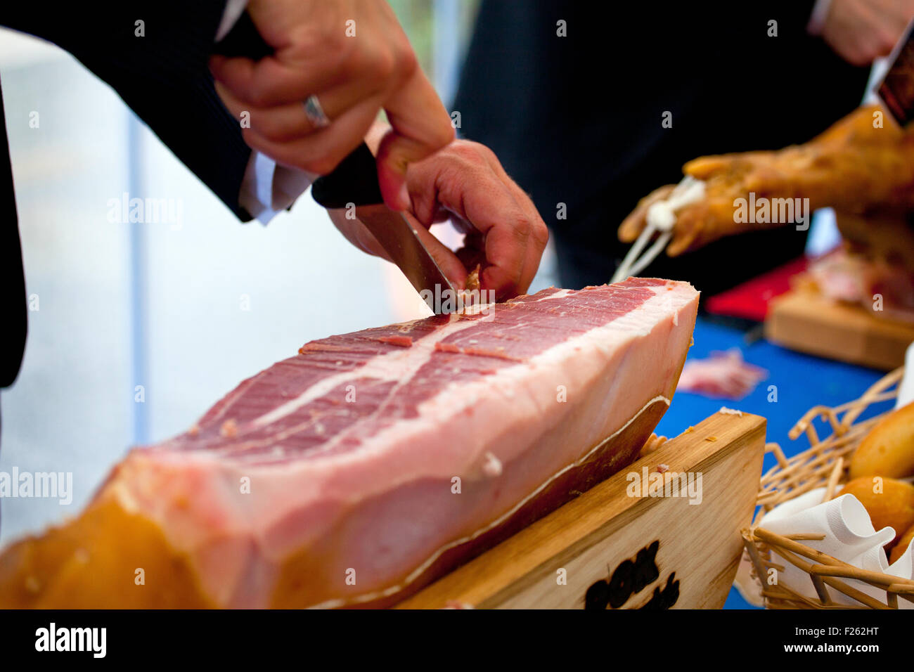 Waiter is slicing Italian raw ham Stock Photo - Alamy
