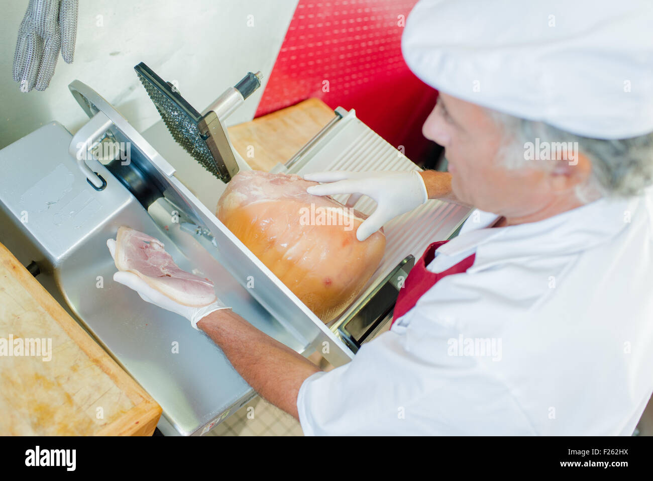 Man slicing meat with machine Stock Photo - Alamy