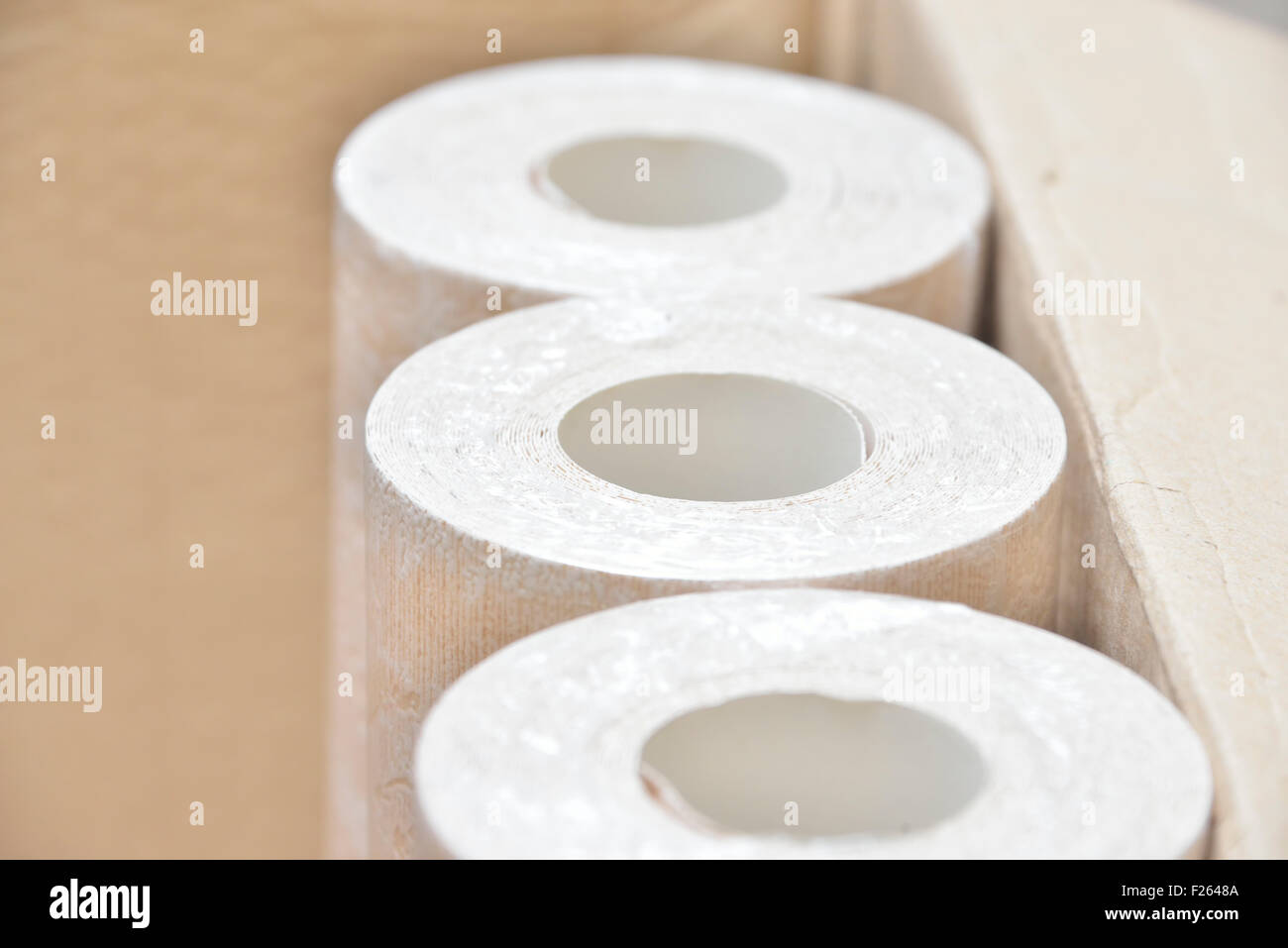 beige wallpaper rolls in cardboard box Stock Photo - Alamy