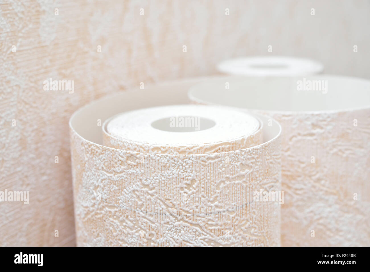 Wallpapering (modern beige wallpaper rolls Stock Photo - Alamy
