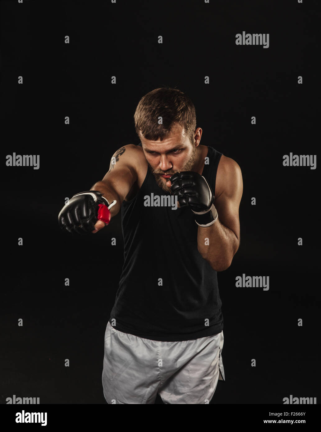 Athletic bearded boxer with gloves on a dark background Stock Photo - Alamy