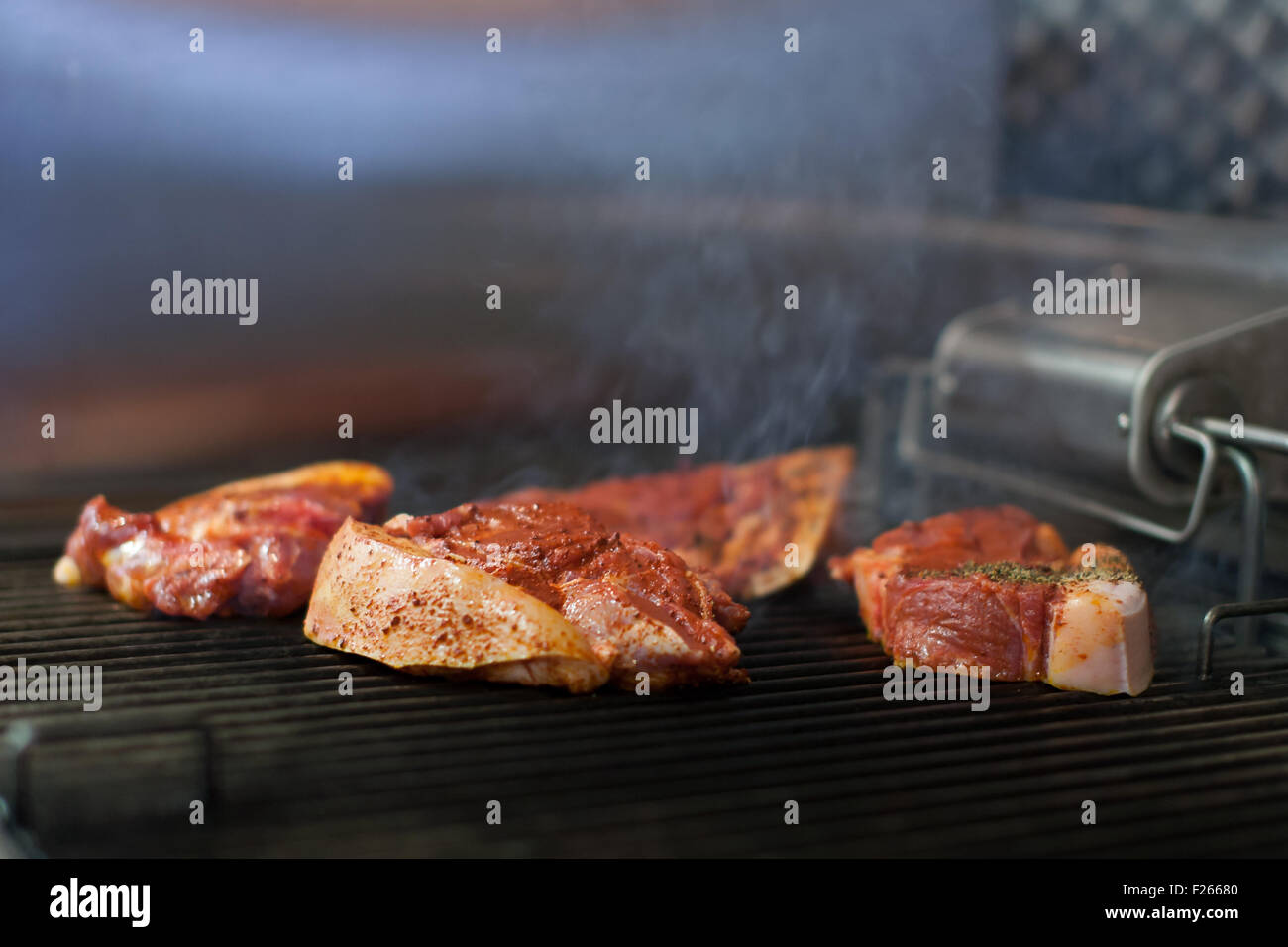 Cooking meat on an open topped grill Stock Photo - Alamy