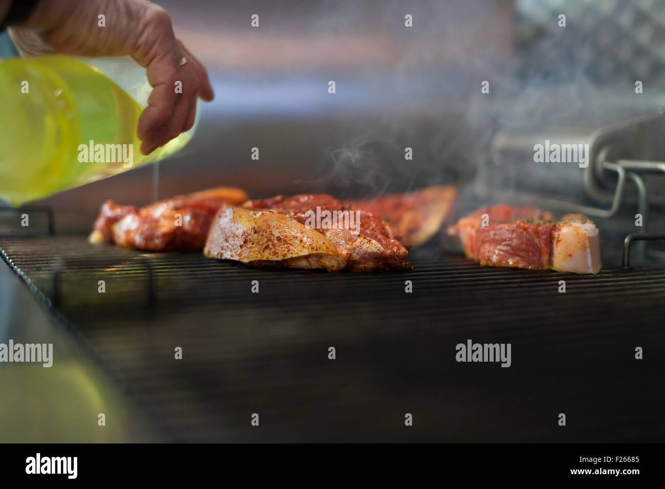 Cooking meat on an open topped grill Stock Photo - Alamy