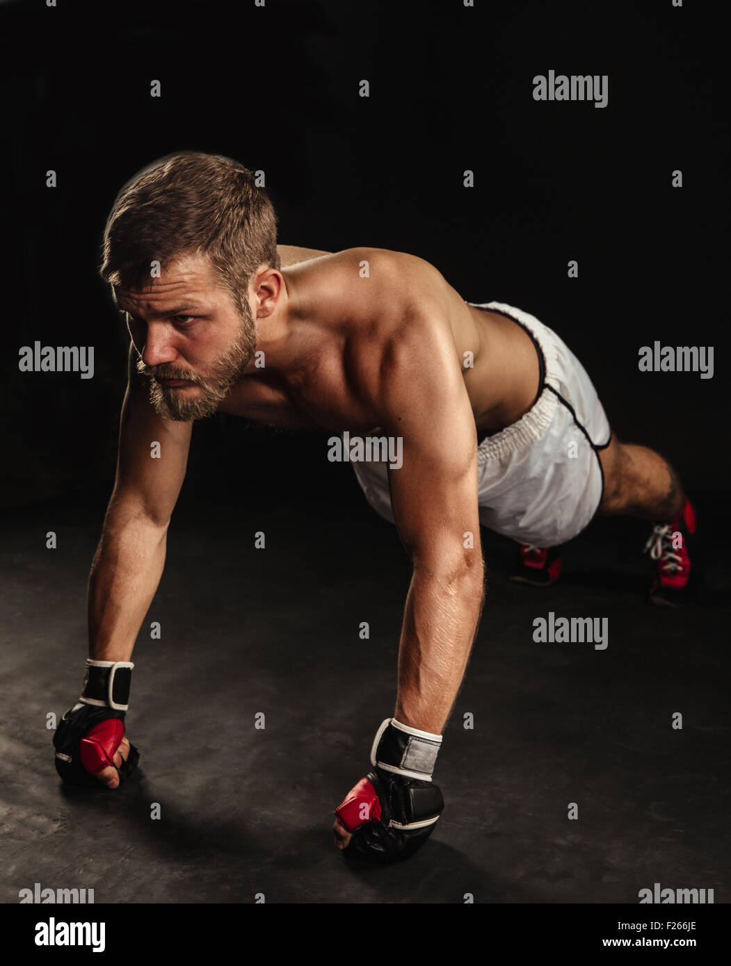 Athletic bearded boxer with gloves on a dark background Stock Photo - Alamy