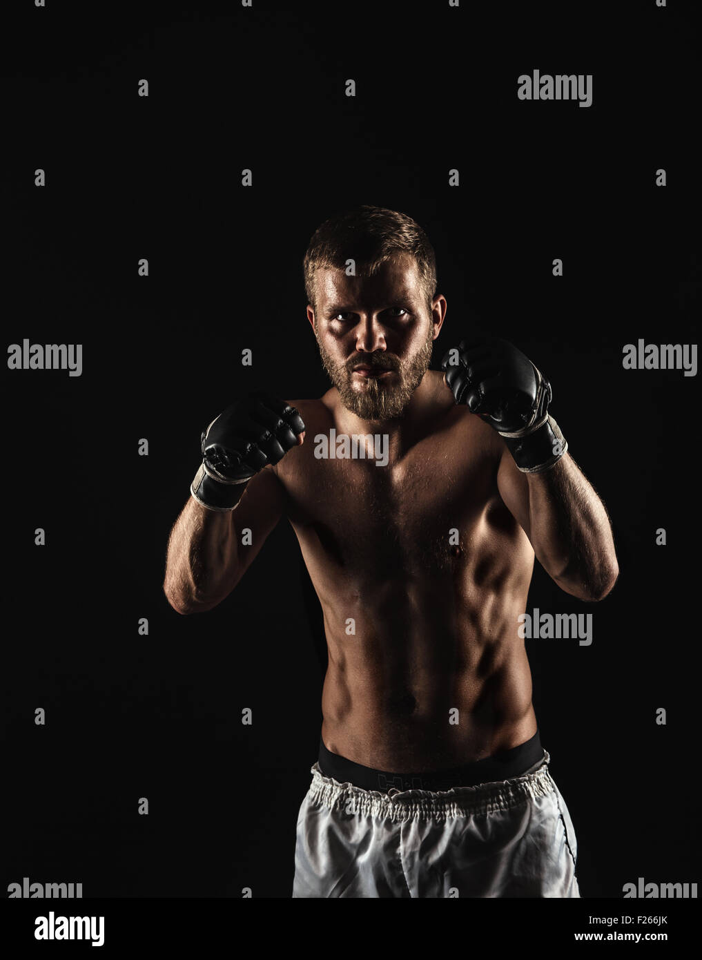 Athletic bearded boxer with gloves on a dark background Stock Photo - Alamy