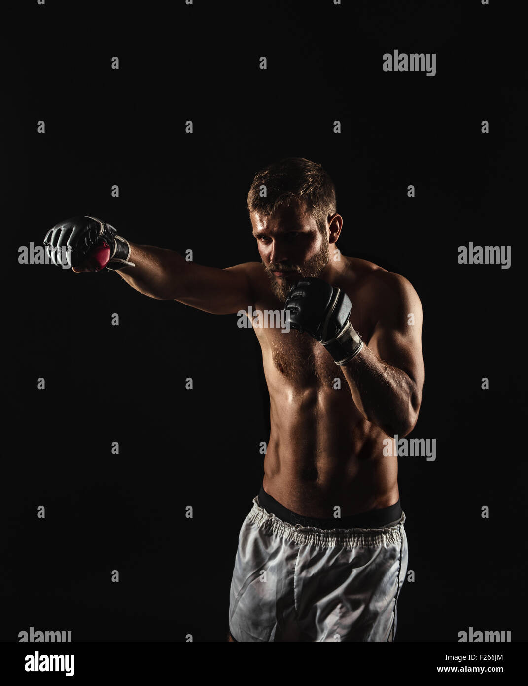 Athletic bearded boxer with gloves on a dark background Stock Photo - Alamy