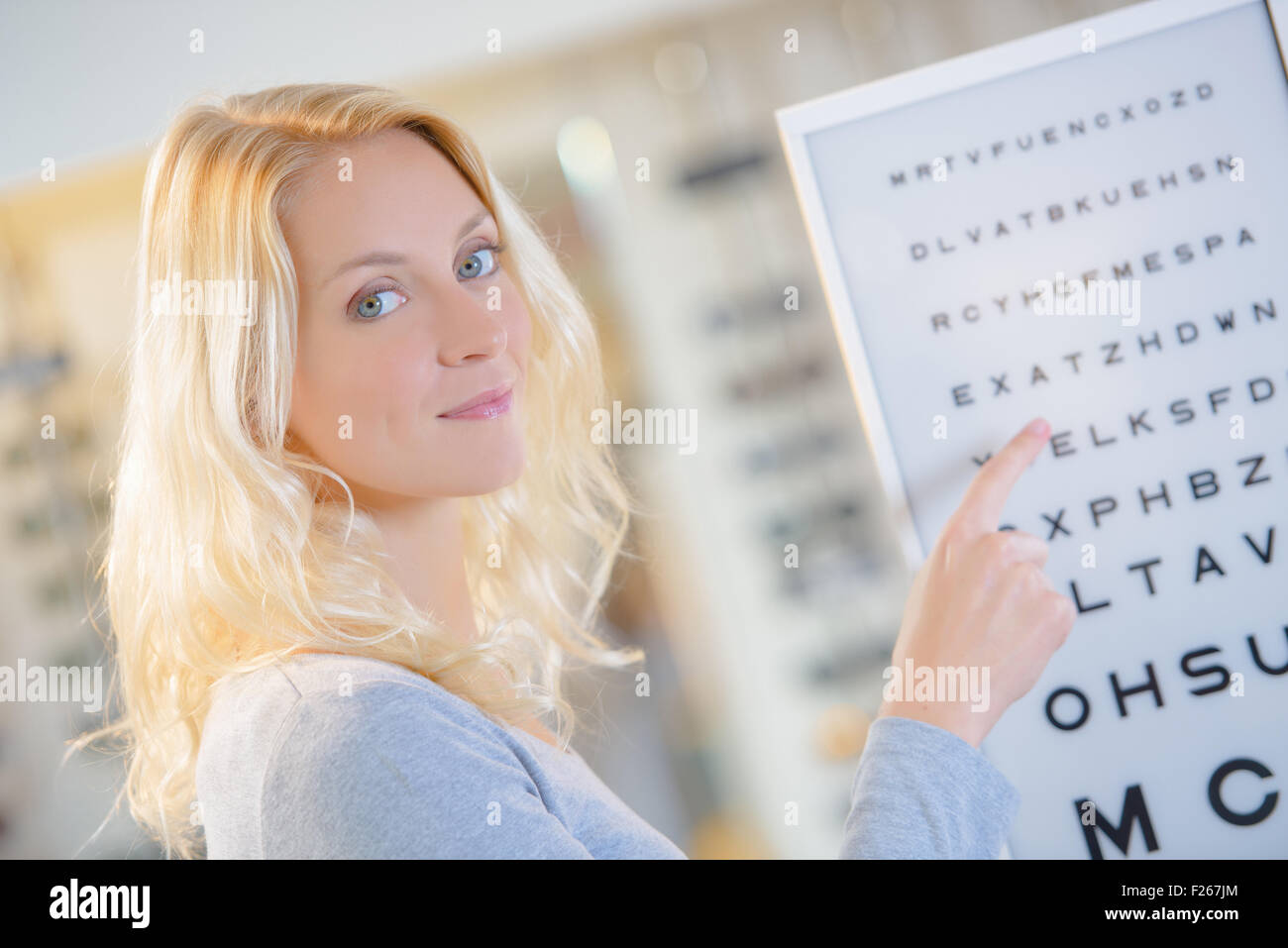 Lady pointing at eye test chart Stock Photo - Alamy