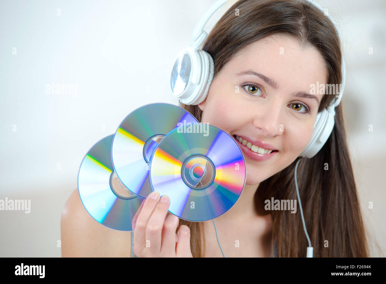 Woman with headphones holding CDs Stock Photo - Alamy