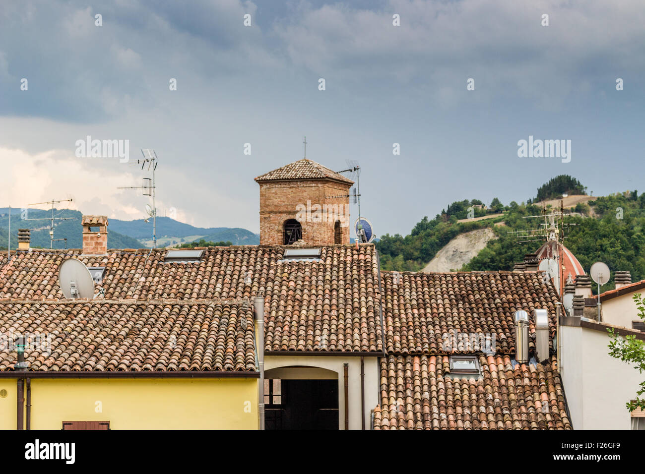 red roofs and grunge walls of ancient buildings and belfry in a country ...