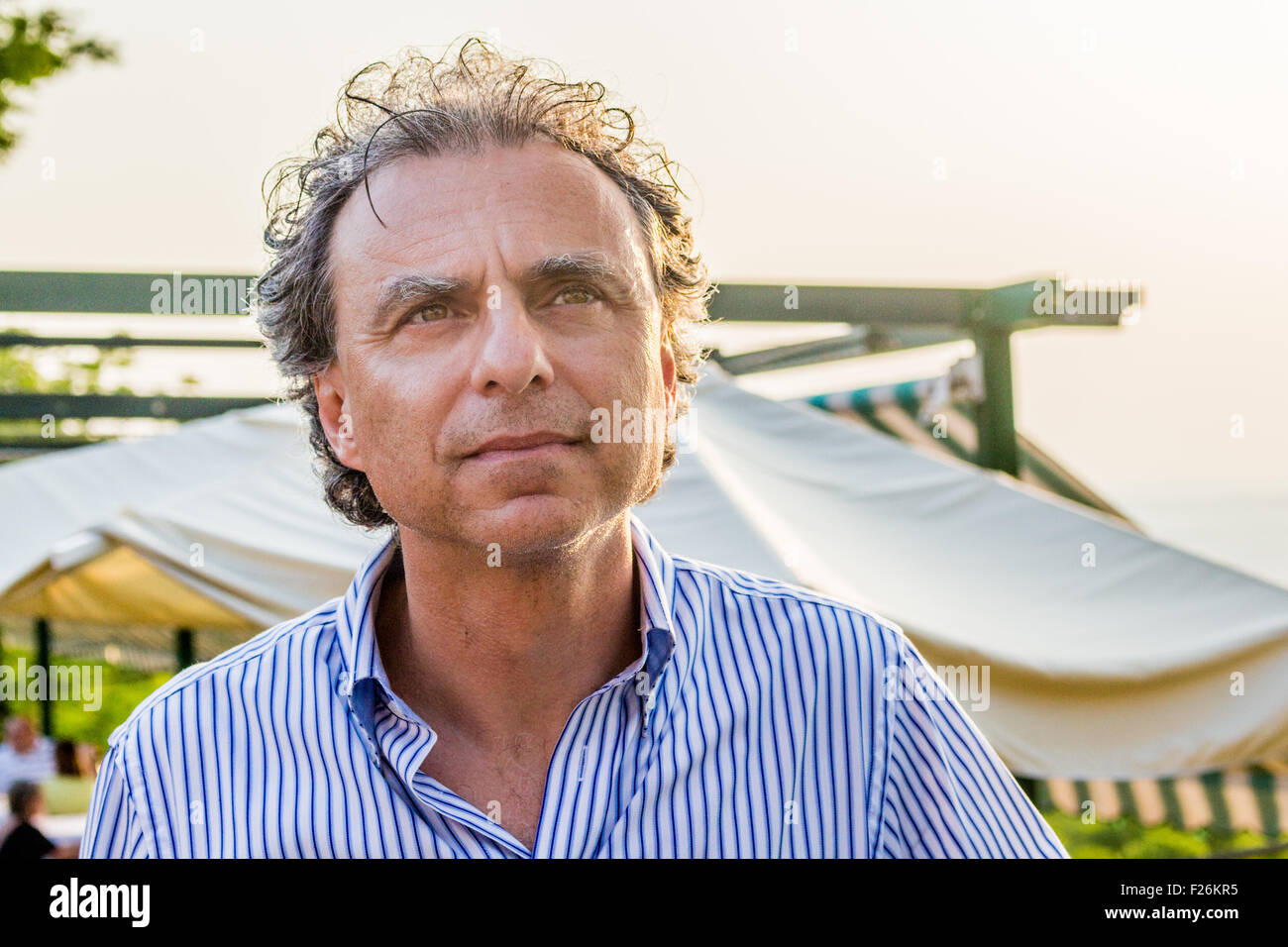 middle-aged man with astonishing and piercing green eyes in a striped ...
