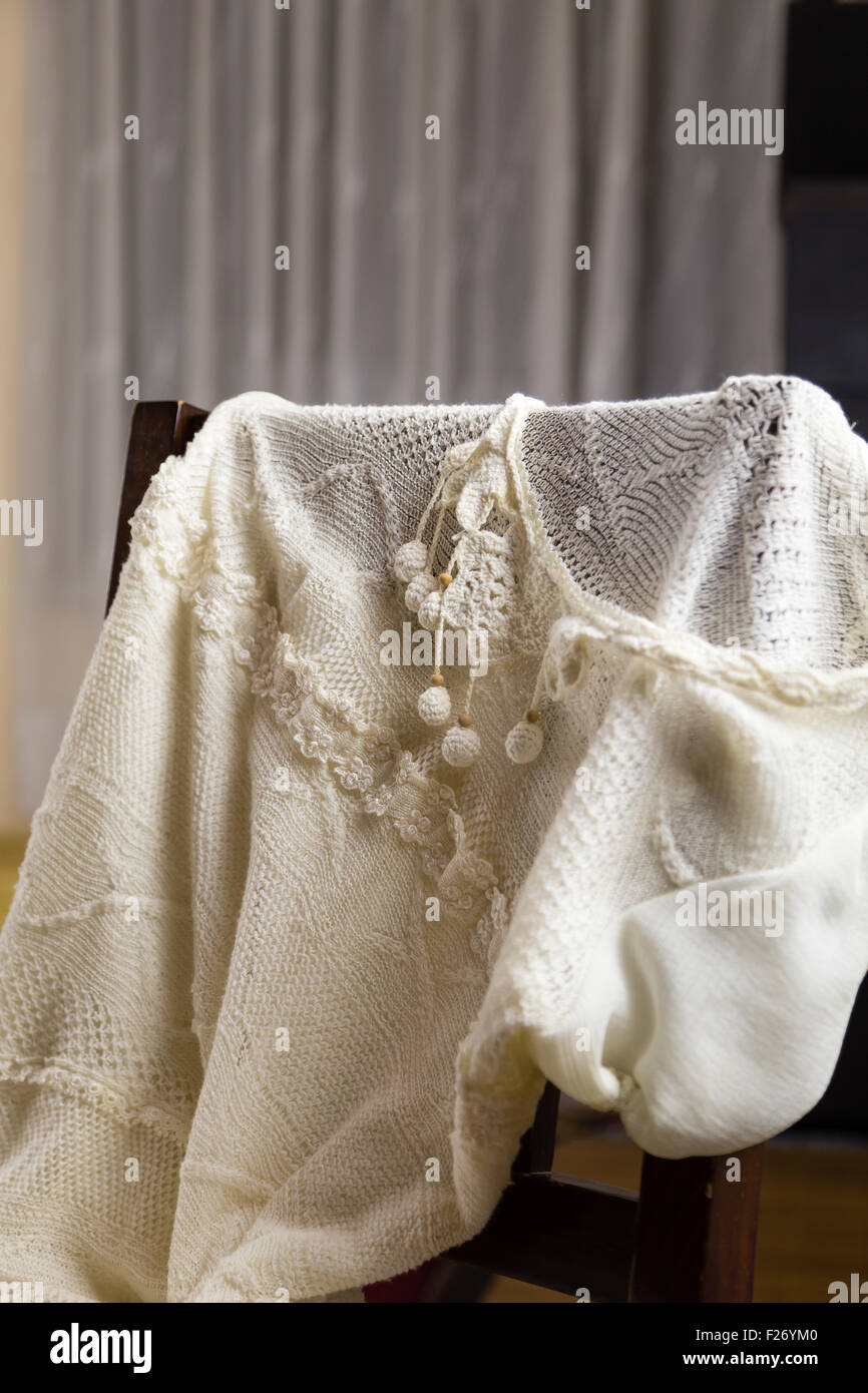 Long white dress draped over brown chair Stock Photo - Alamy