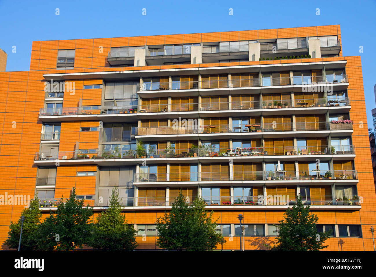 A modern orange building with rows of balconies Stock Photo - Alamy