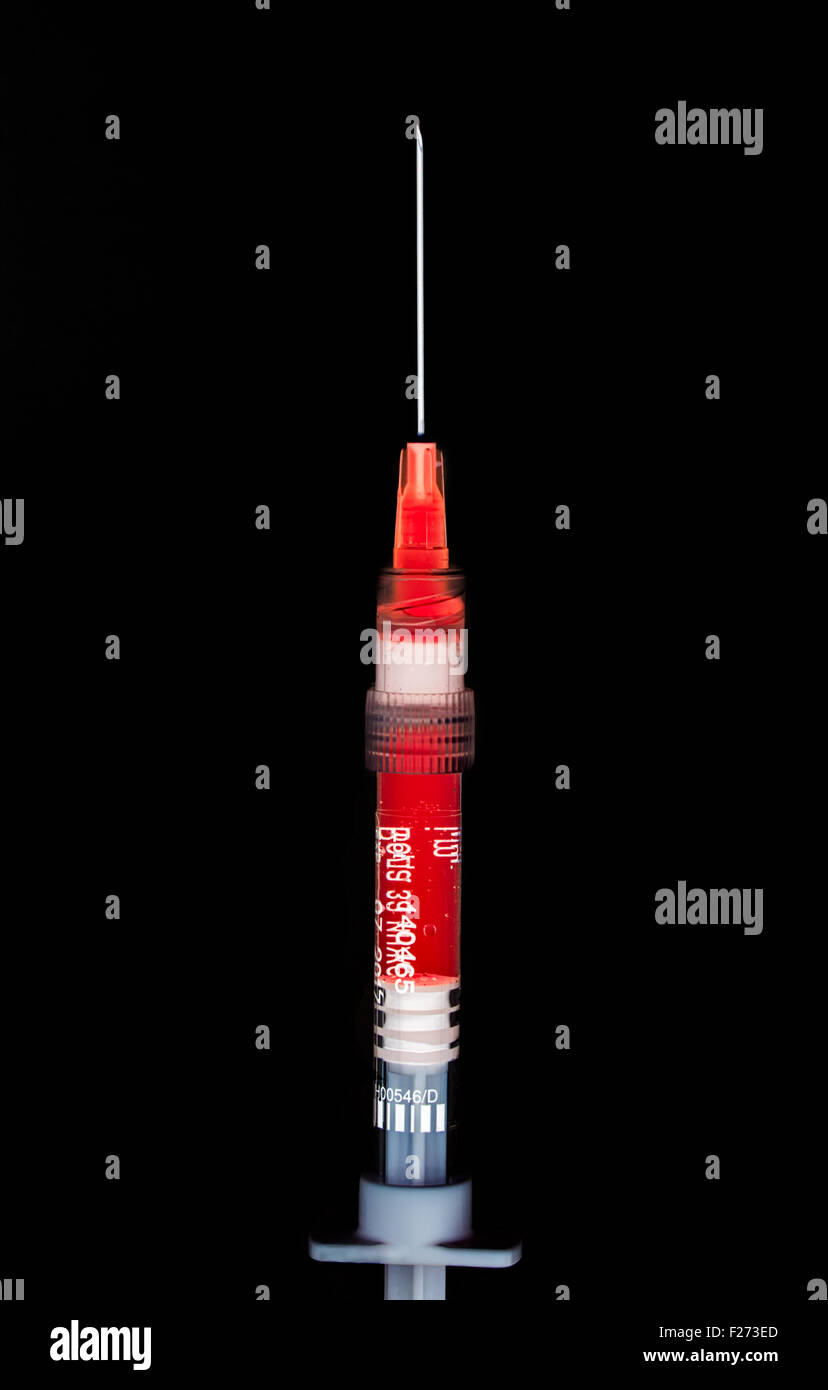 Single syringe with red fluid isolated on black background Stock Photo ...