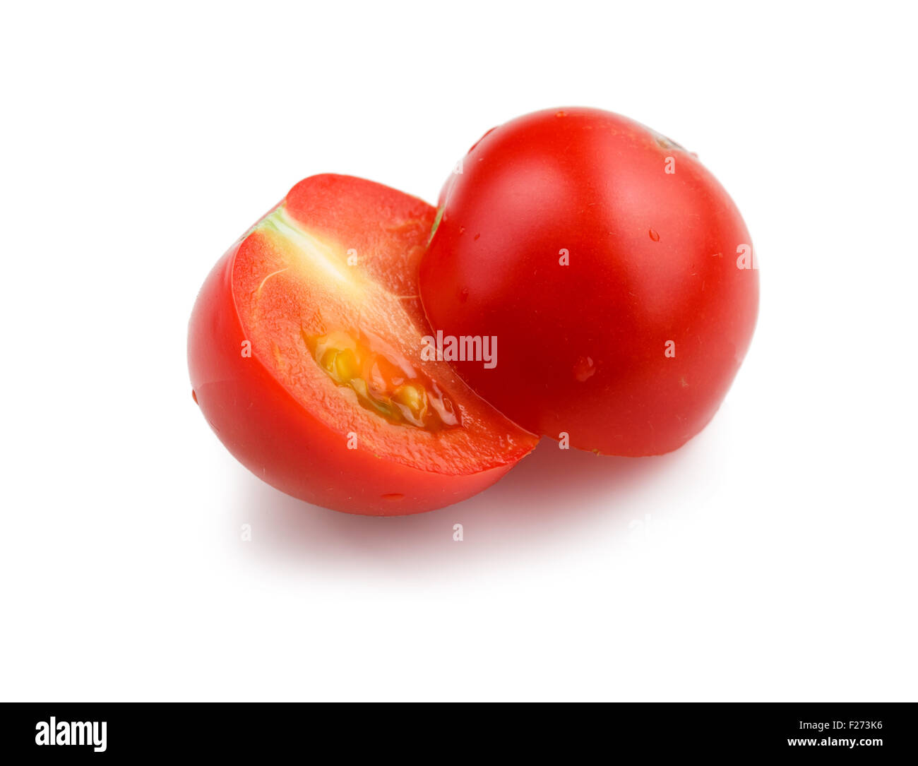 One tomato split in half isolated on white background Stock Photo - Alamy