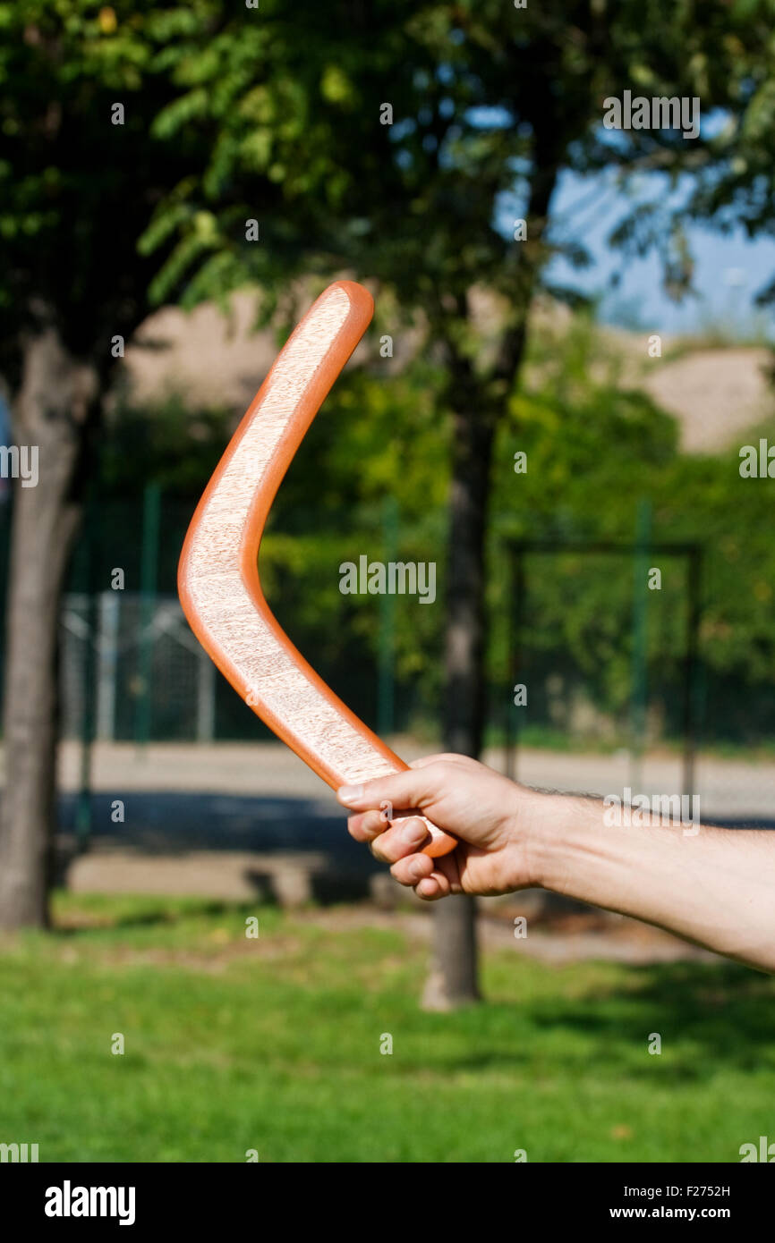 Boy holding wooden boomerang toy Stock Photo - Alamy