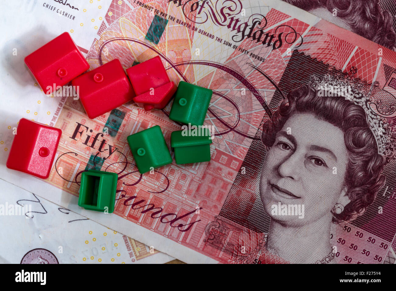 Imitation model red and green plastic houses with chimneys rest on top ...