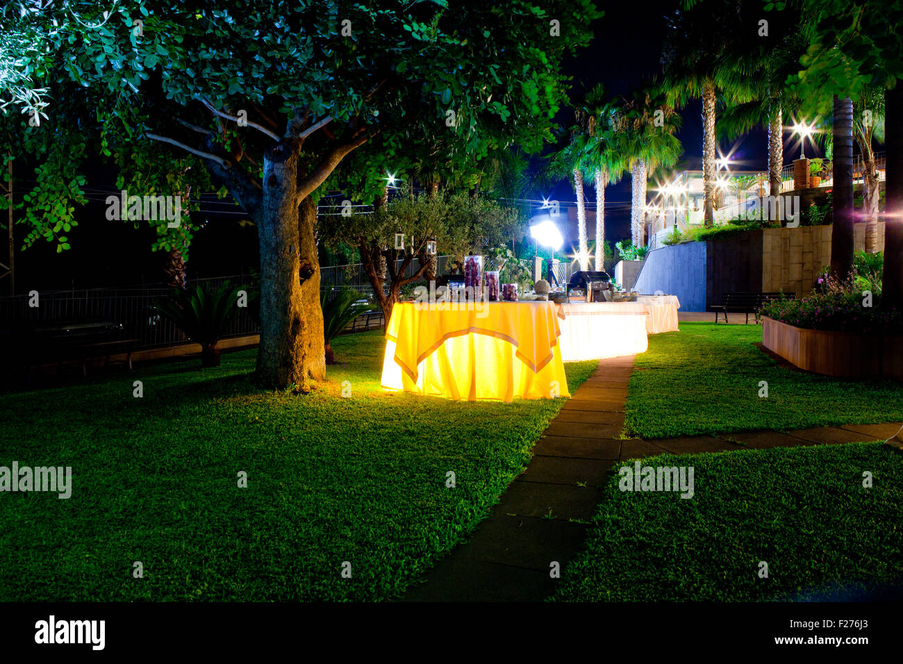 Night view of table set in the garden Stock Photo - Alamy