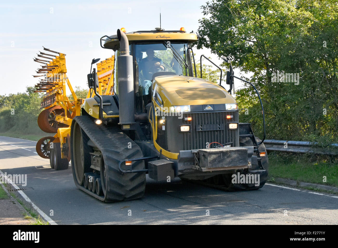 Farmer driving Caterpillar challenger tractor and folded disc harrow ...