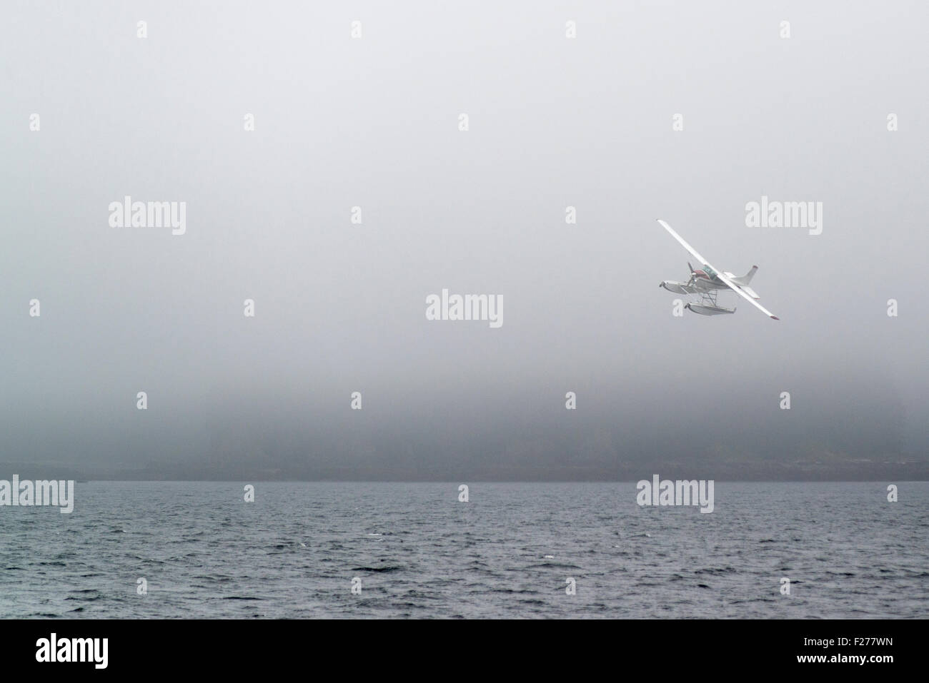 Float plane flying below the clouds in Southeast Alaska Stock Photo - Alamy