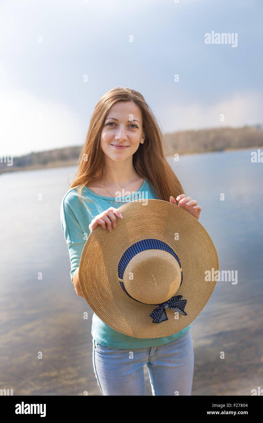 Freckled happy girl holding thatch hat in her hands and looking at camera Stock Photo - Alamy