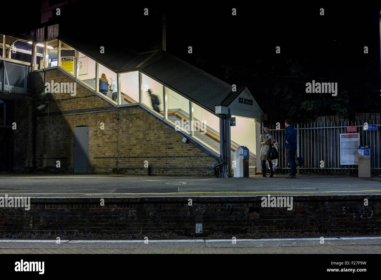 A commuter station and train at night in London Stock Photo - Alamy